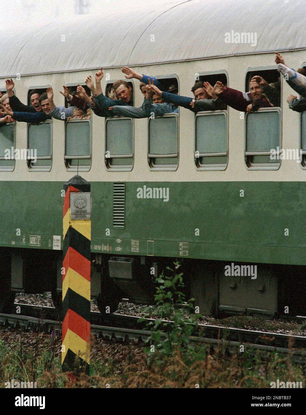 Happy East Germans wave out of the train that brings them from East to ...