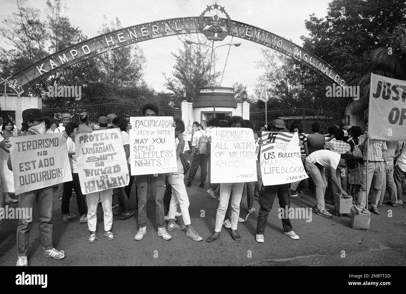 Protesters hold anti-military signs at the gate of Camp Aguinaldo, the ...