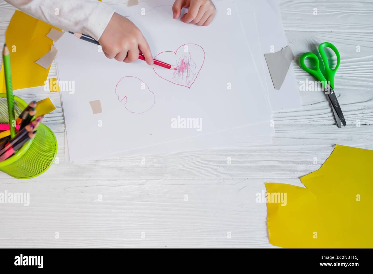 The child drew a heart on white paper. Creativity of children. Drawing ...