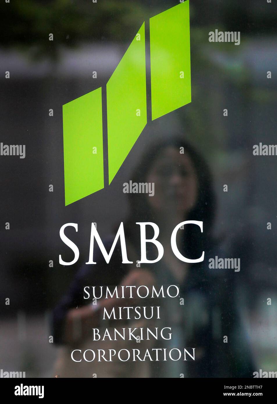 A woman walks in front of the Sumitomo Mitsui Banking Corporation ...