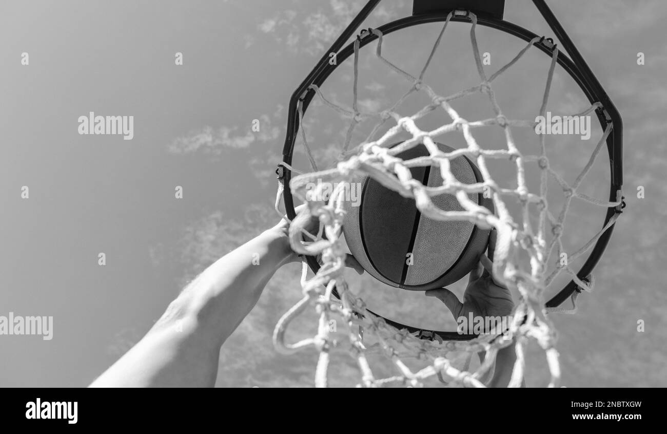 man dunking basketball ball through net ring with hands, sport Stock ...