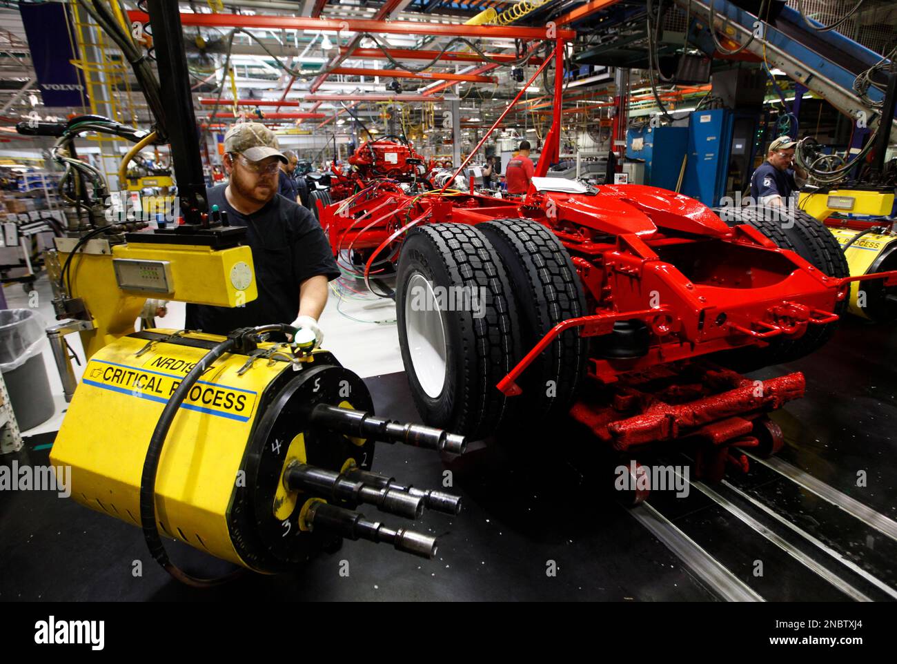 A worker uses a super size impact wrench to tighten the lug nuts on ...
