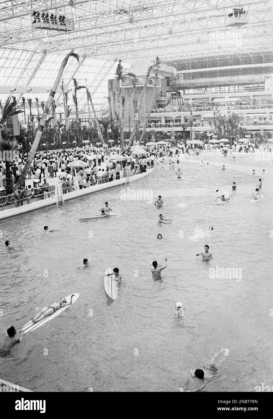 Japanese youths enjoy indoor surfing in a big swimming pool where about ...