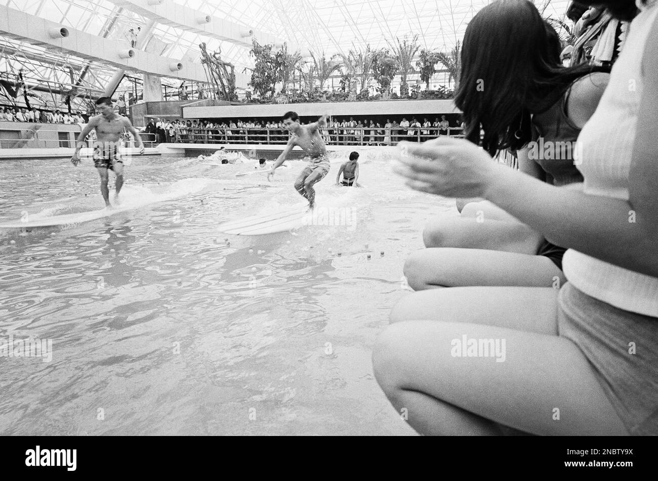 Japanese youths enjoy indoor surfing in a big swimming pool where about ...