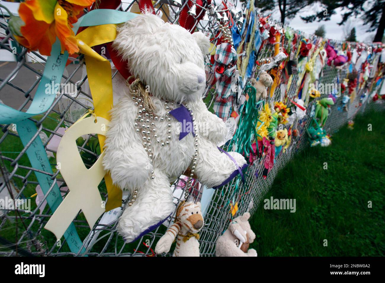 A weathered teddy bear hangs on a cyclone fence at "Kyron's Wall of ...