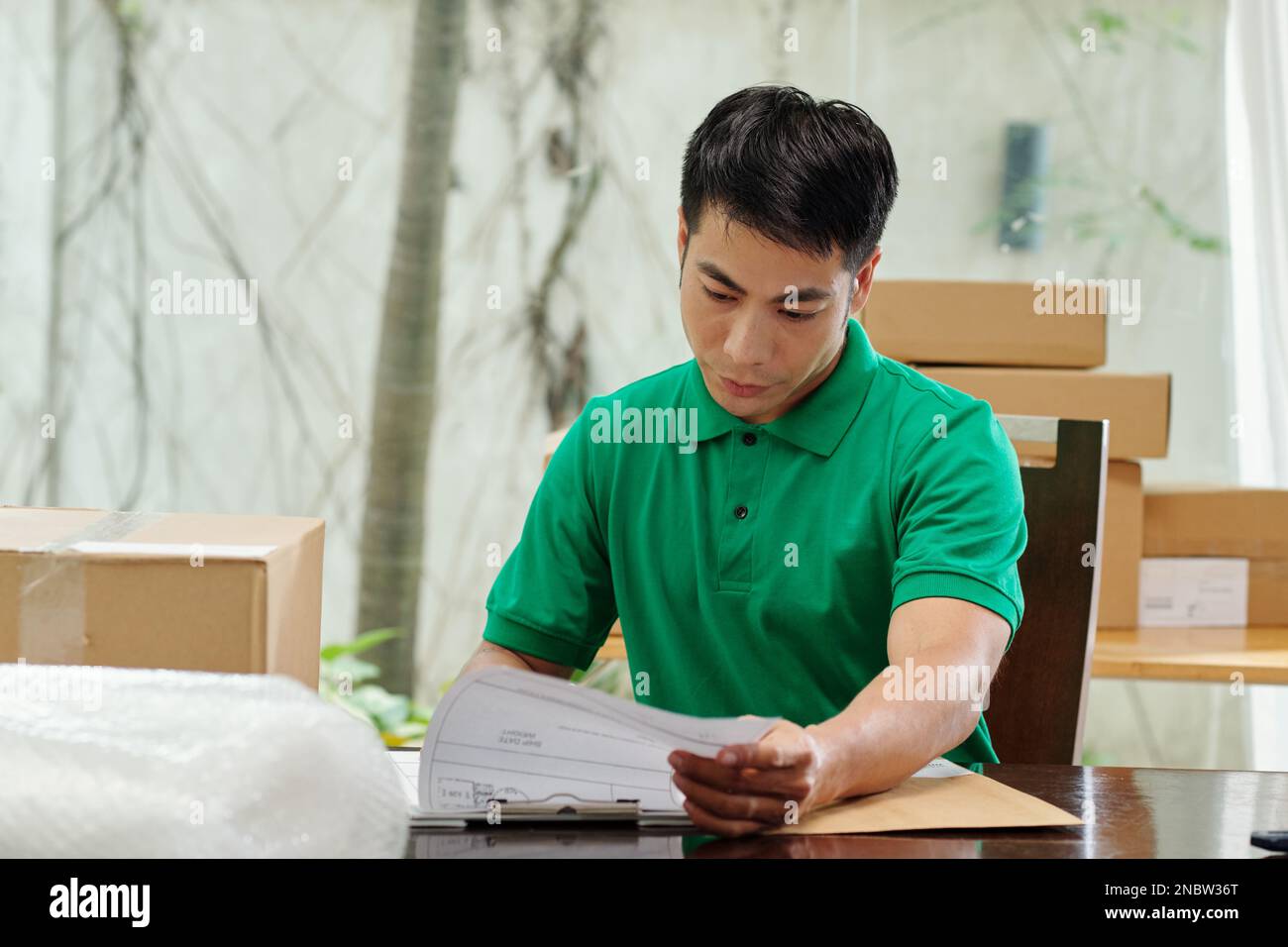 Solopreneur filling documents before sending order to his customers ...