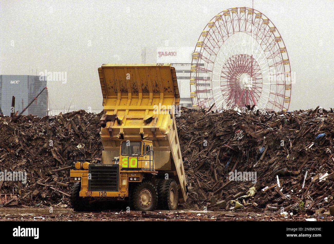 A truck unloads debris from demolished buildings into piles of rubble ...