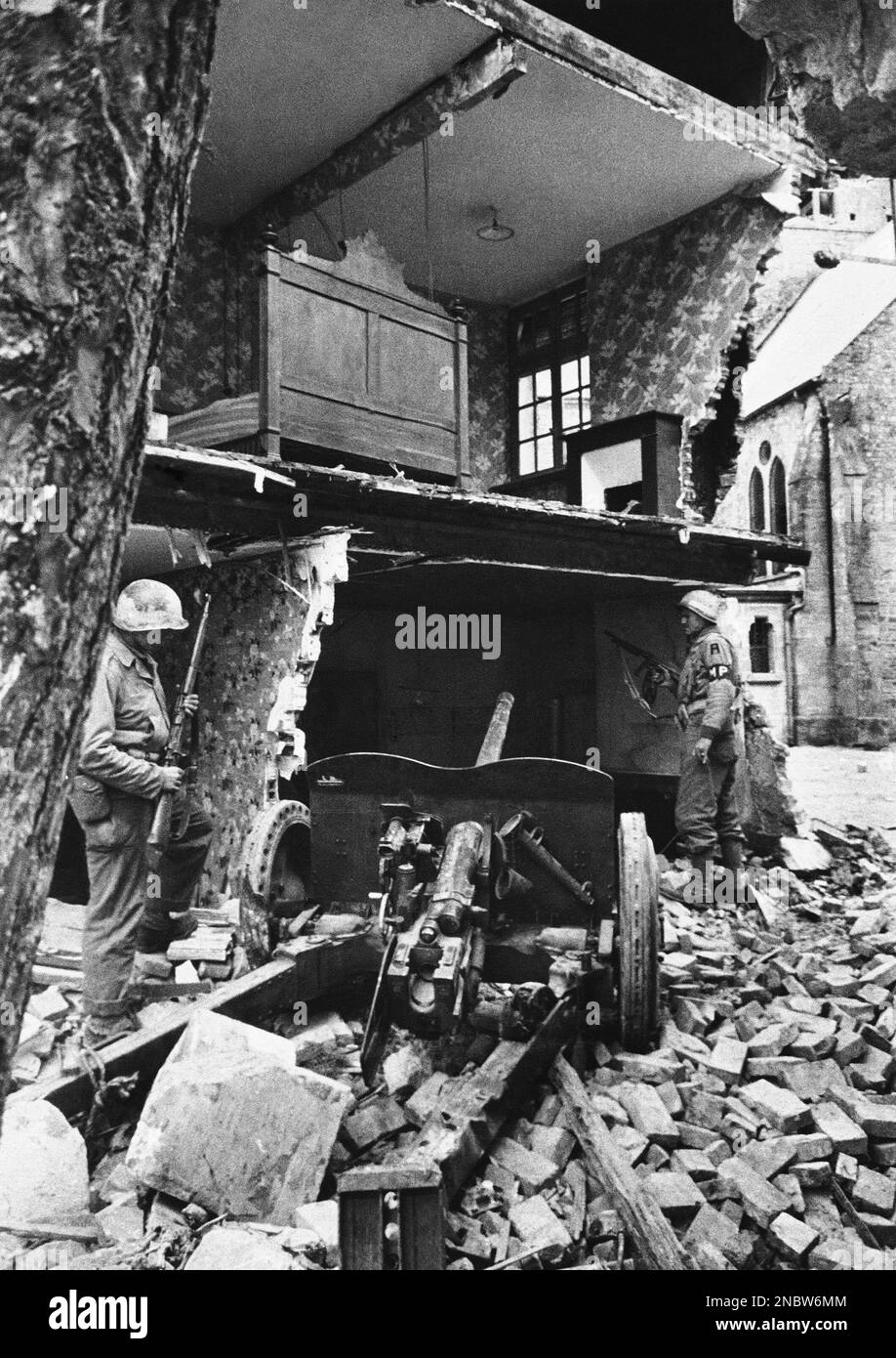 American soldiers move through the wreckage surrounding a German anti ...