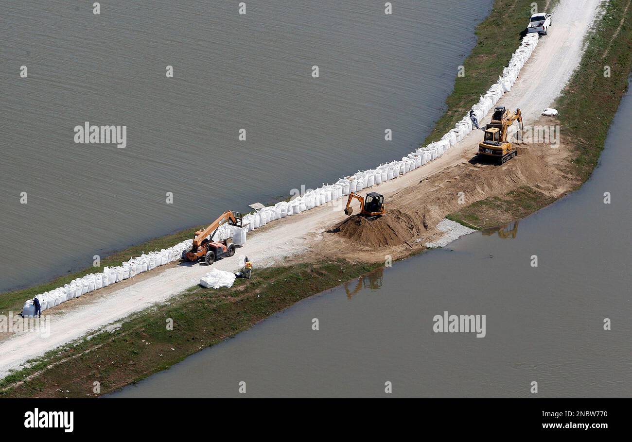 Workers top a levee with sand bags near the Mississippi River near ...