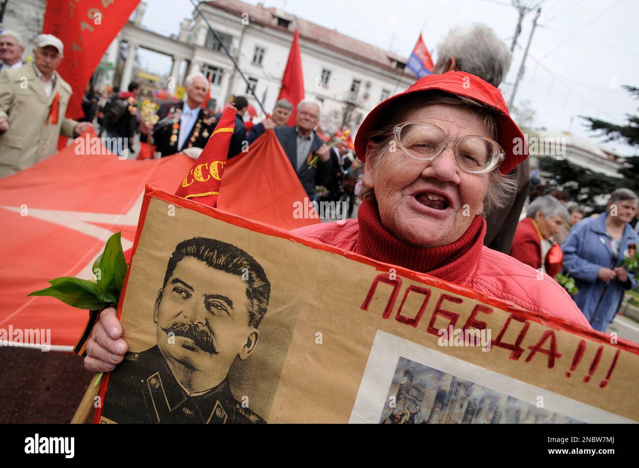 A woman shouts slogans and holds a poster with a portrait of Soviet ...