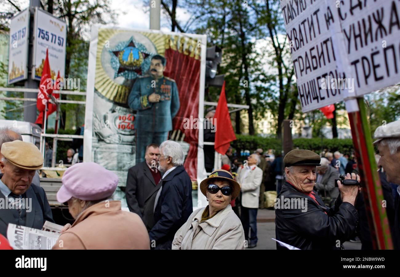 Elderly people gather near the huge portrait of Soviet Dictator Josef ...