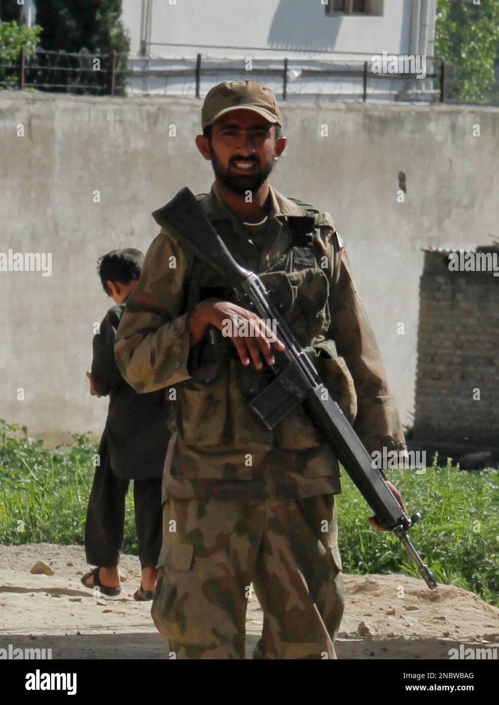 A Pakistan army soldier secures a street close to the house of former ...