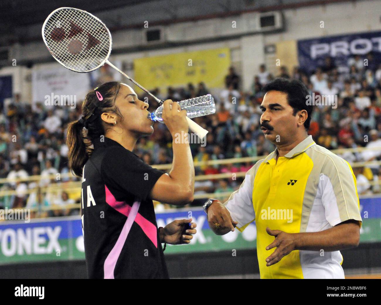 India's Saina Nehwal, left, drinks water next to her coach during a ...