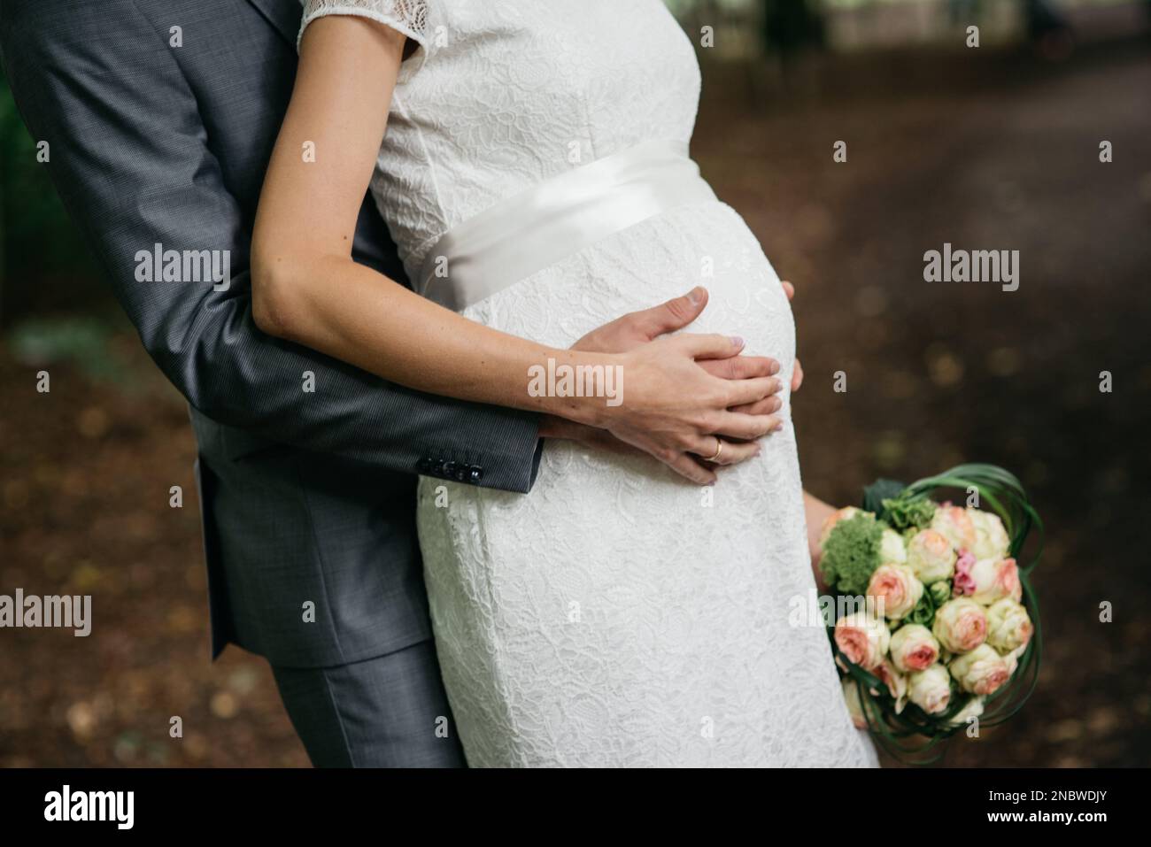 the groom at the wedding holds the belly of the pregnant bride Stock ...