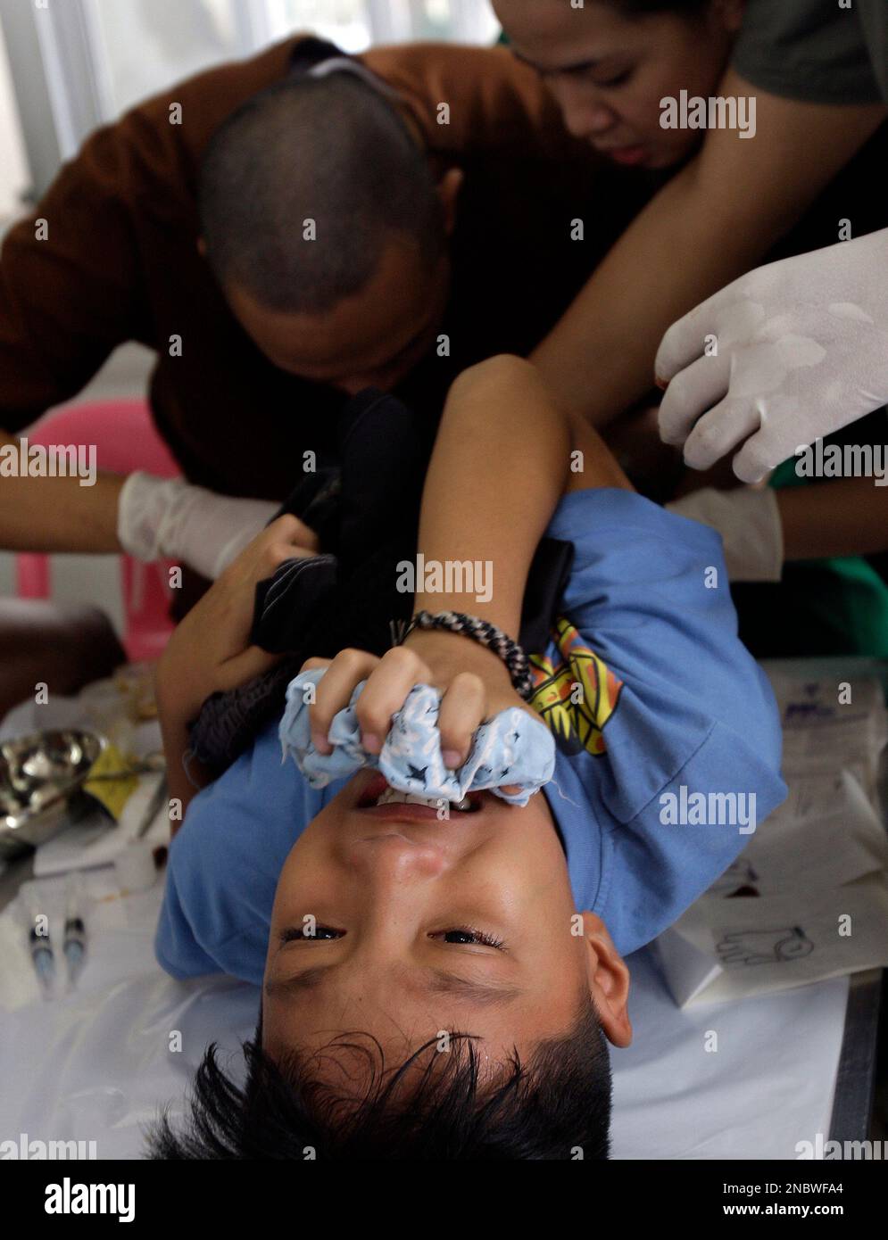 A boy tries to control himself as doctors work on him during a free ...