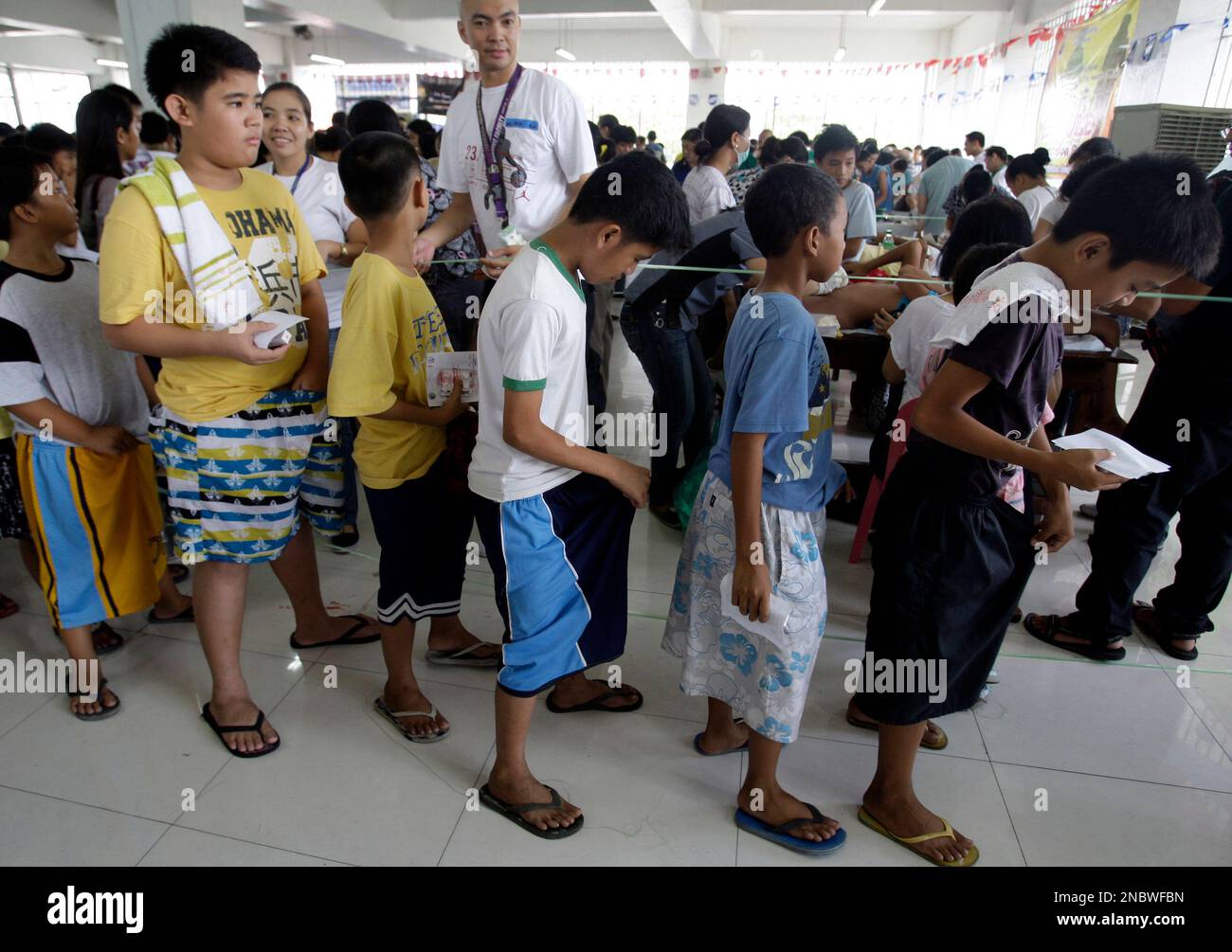 Newly circumcised boys wait in line to receive free medicine during a ...