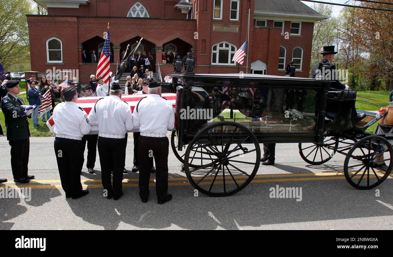 The flag-draped casket of U.S. Army Capt. Joshua McClimans is placed ...
