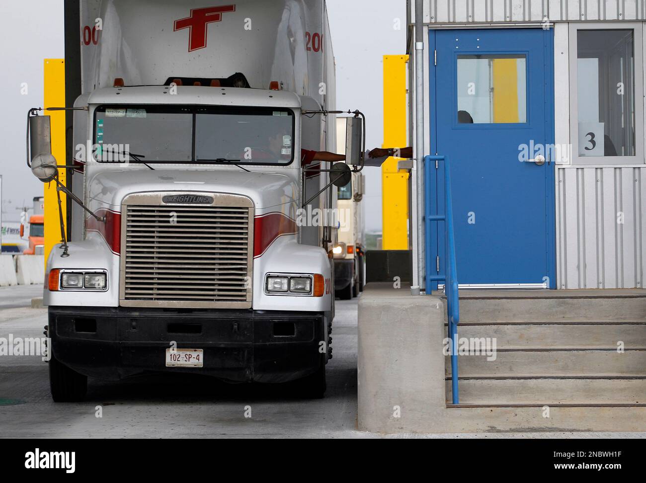 Truckers pass through inspection booths for commercial traffic heading ...