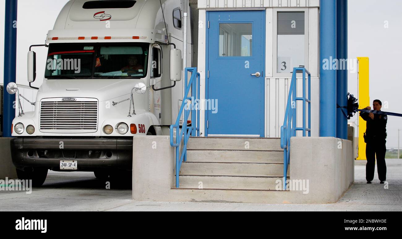 An official places ribbon across one of seven new inspection booths for ...