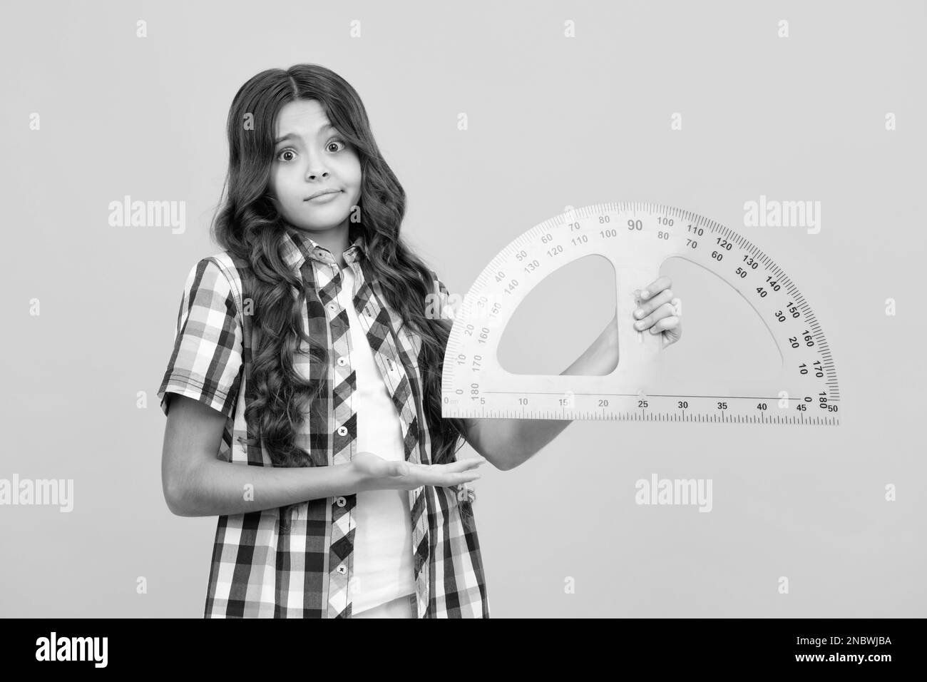 Back to school. School girl hold ruler measuring isolated on yellow ...