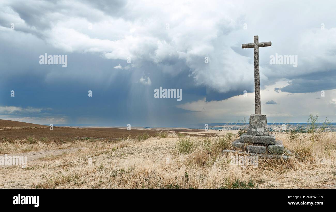 aged landscape with a cross in his right hand Stock Photo - Alamy