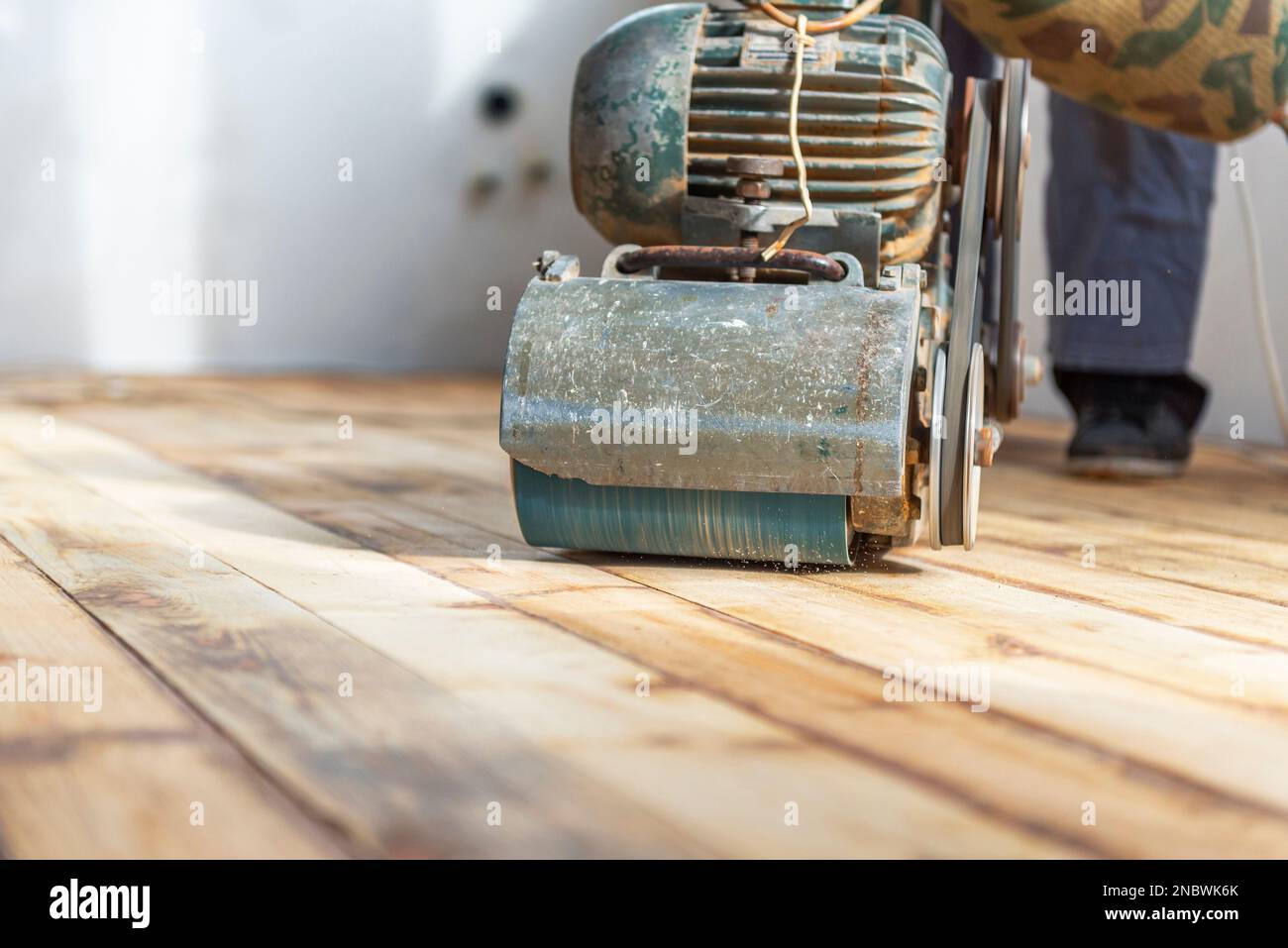 Worker polishing parquet floor with grinding machine Stock Photo - Alamy