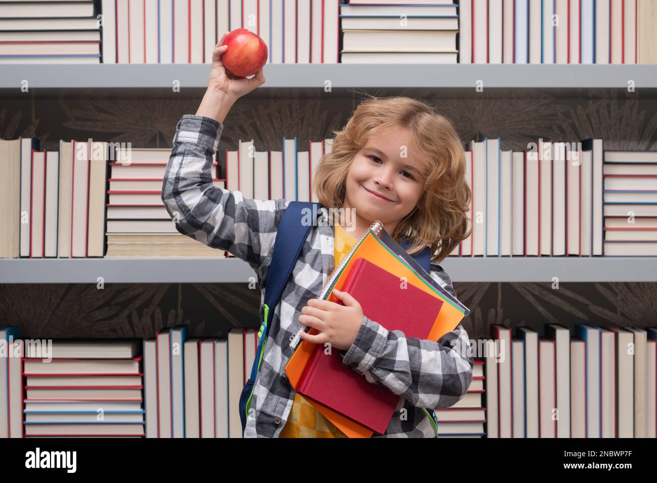 School boy with books and apple in library. Nerd school kid. Clever ...