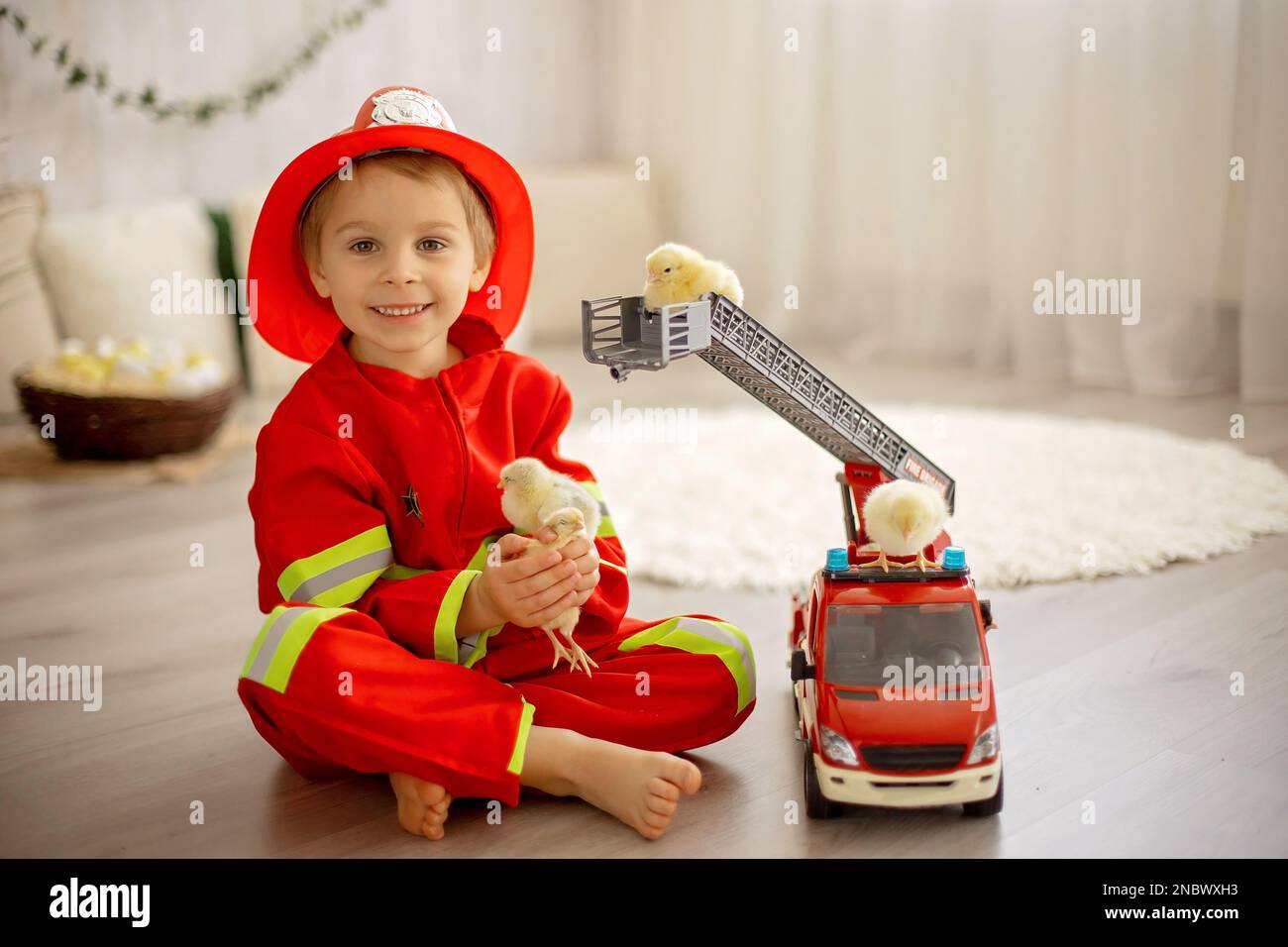 Little toddler child, playing with fire truck car toy and little chicks ...
