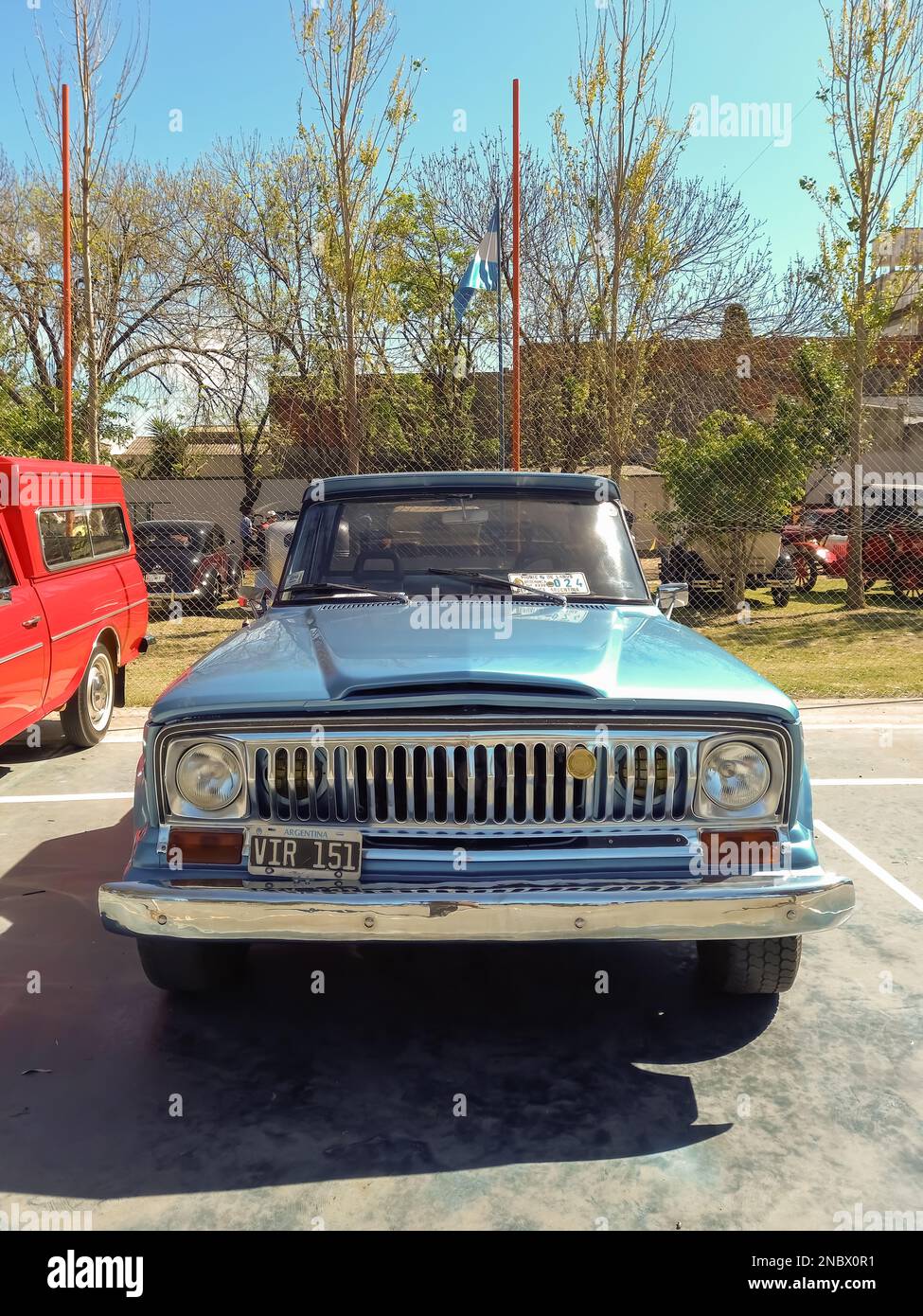 old metallic blue 1970s IKA Jeep Gladiator pickup truck in a park ...