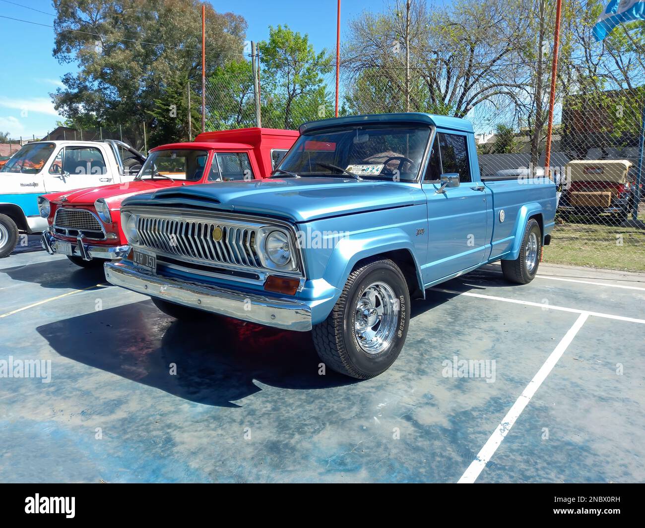 old metallic blue 1970s IKA Jeep Gladiator pickup truck in a park ...