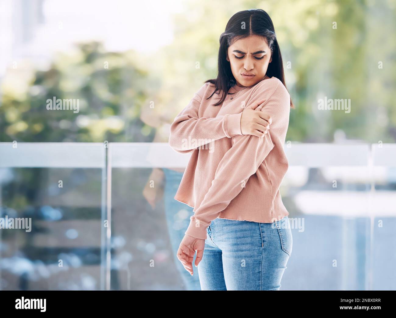 Arm, pain and mockup with an indian woman holding her shoulder on a ...