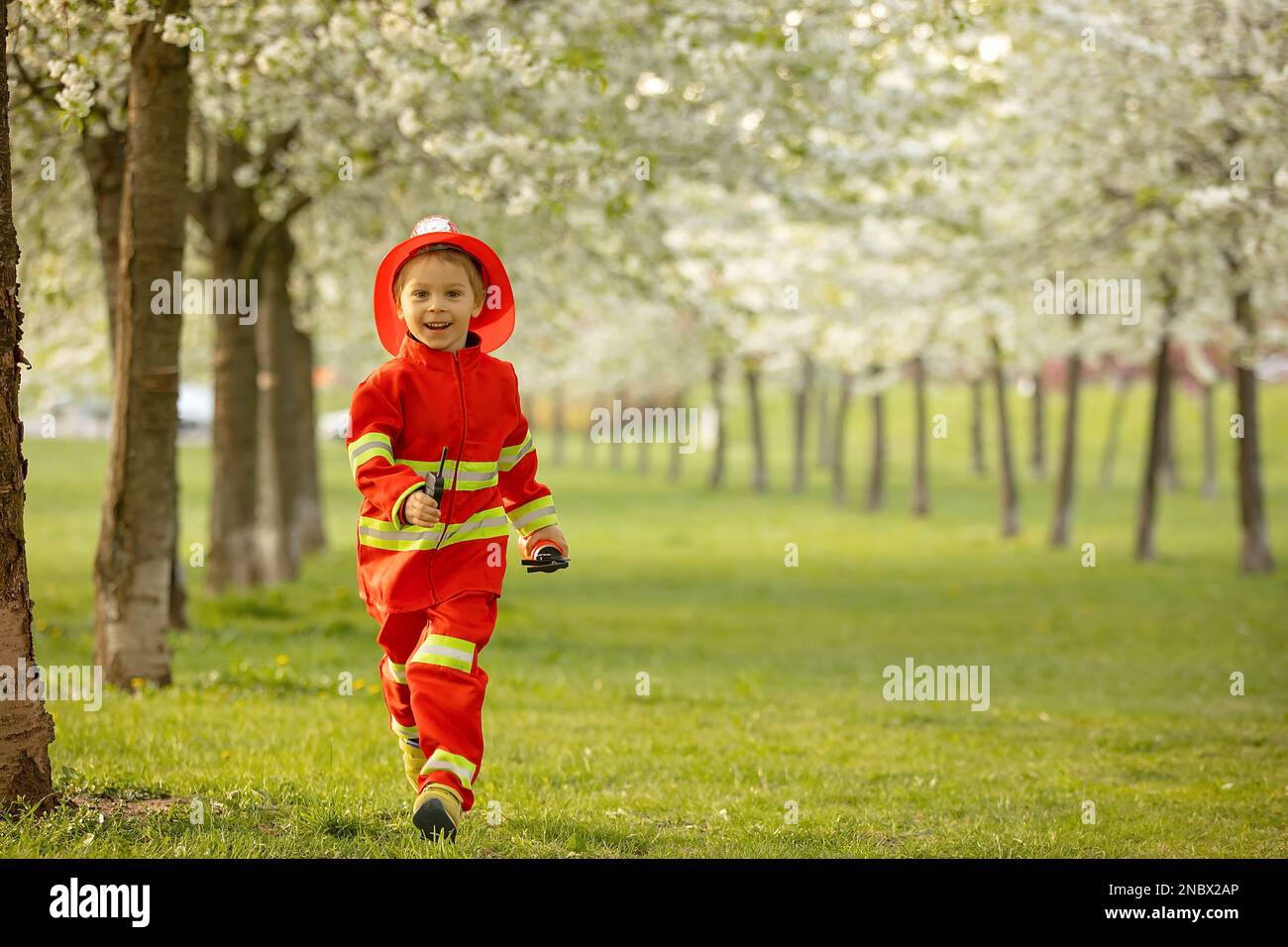 Little toddler child with fireman costume in park, pretending to be ...