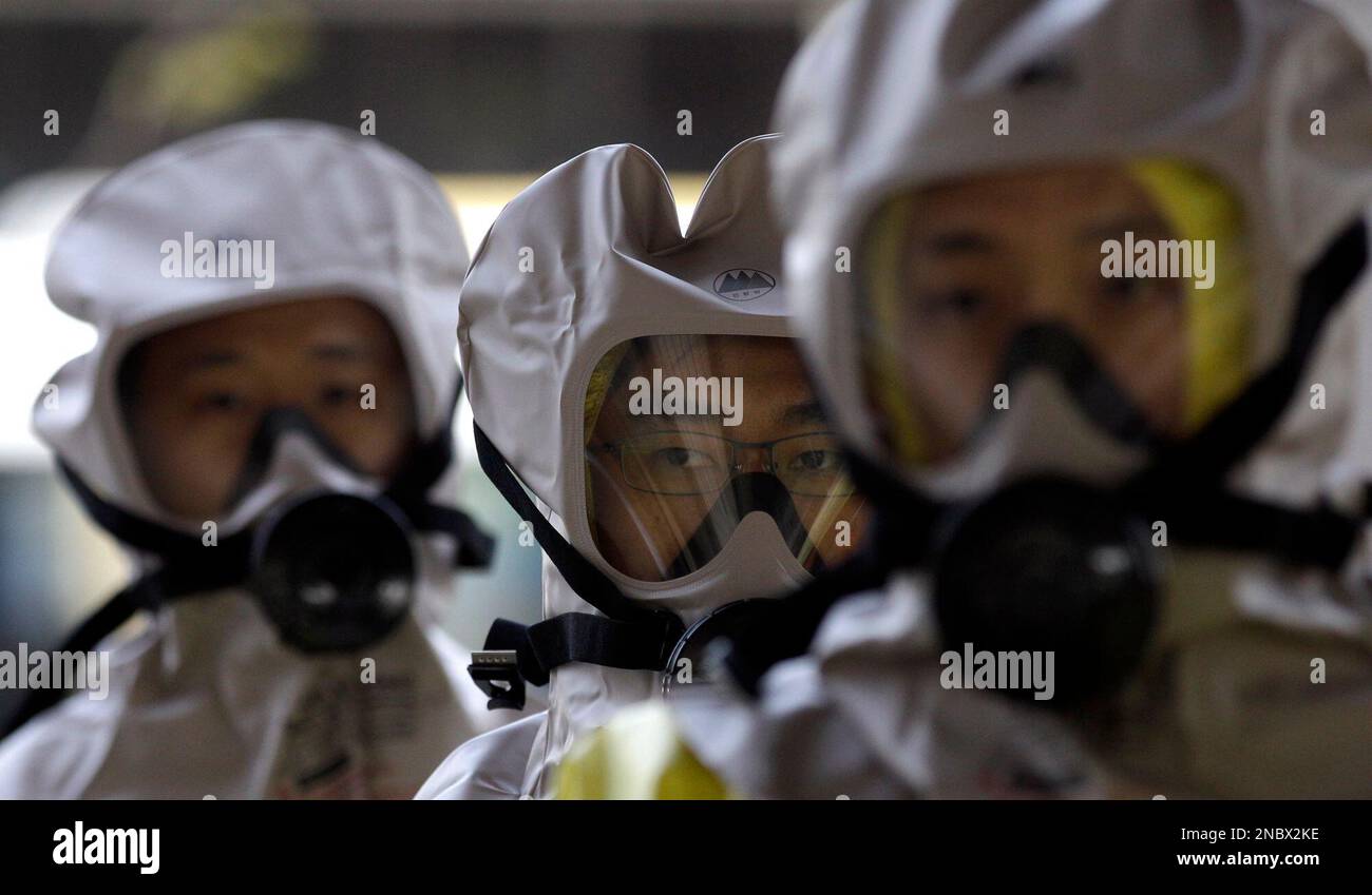South Korean workers wear gas masks from a mock chemical attack during ...