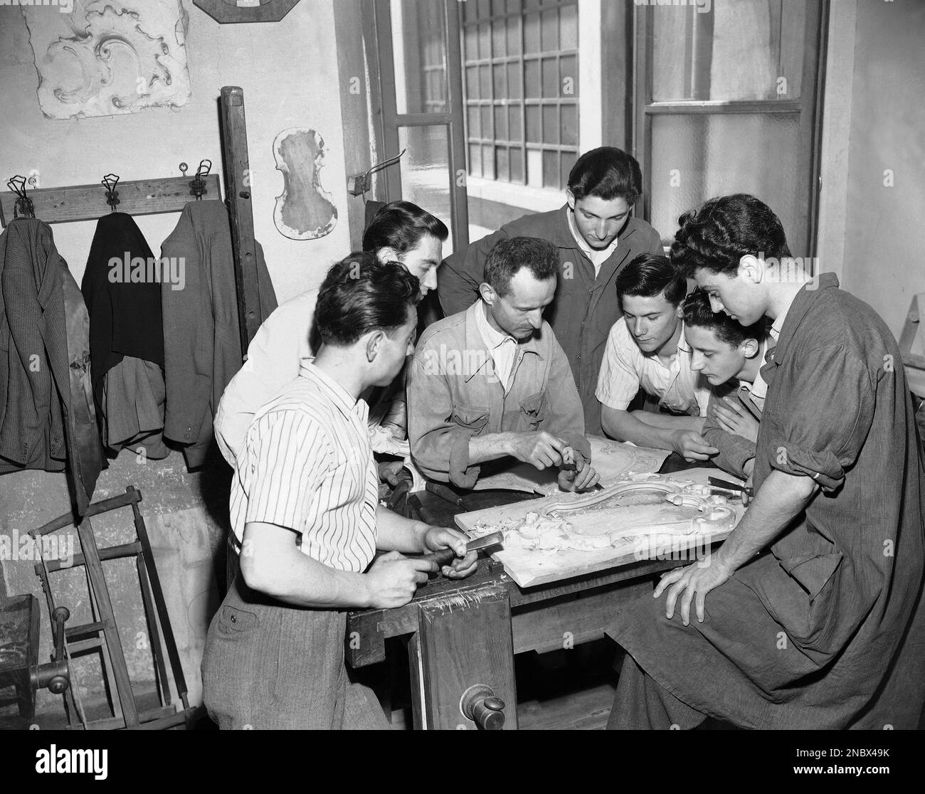 Teacher Ernesto Dragoni (center of group) instructs a class in wood ...