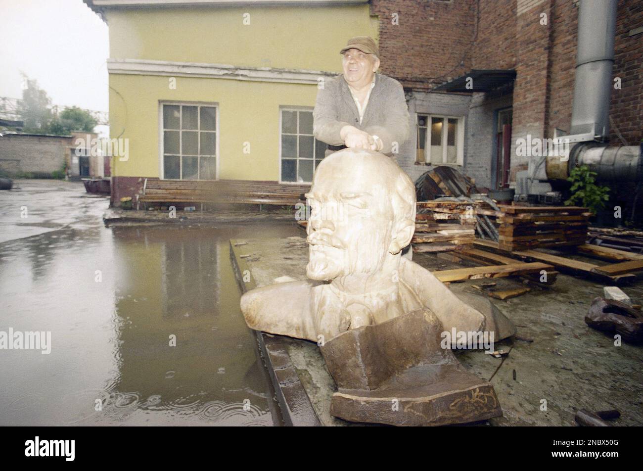 Factory worker Nikolai Leonidov moves a giant bust of Vladimir I. Lenin ...