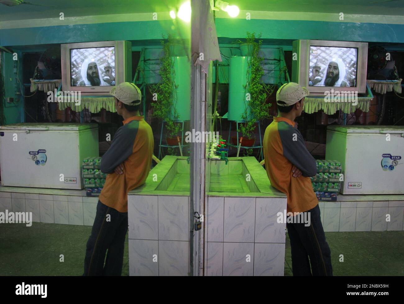 An Afghan man watches television coverage announcing the killing of Al ...