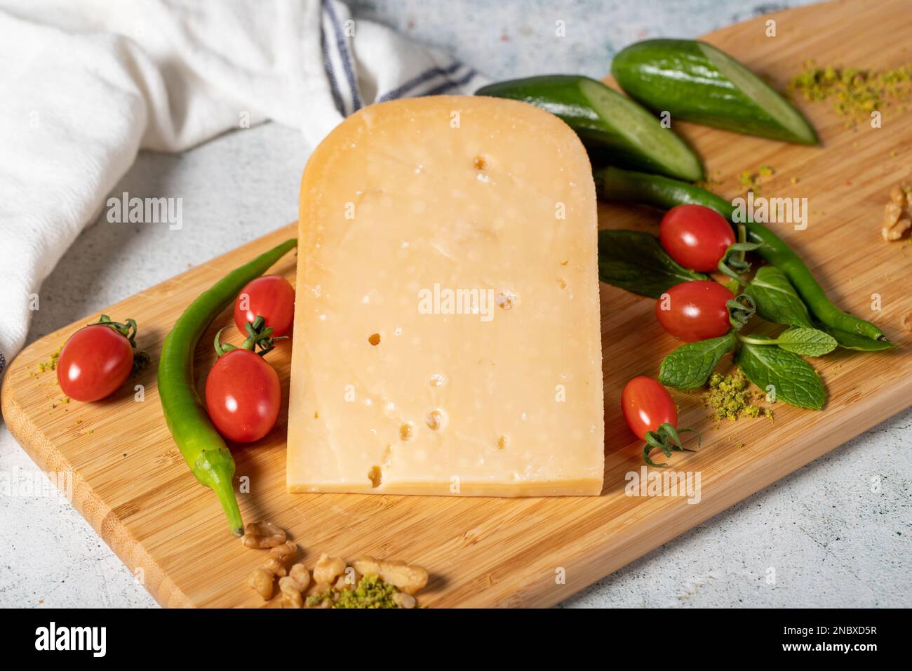 Gouda cheese. Piece of gouda cheese on wooden cutting board. Cheese ...