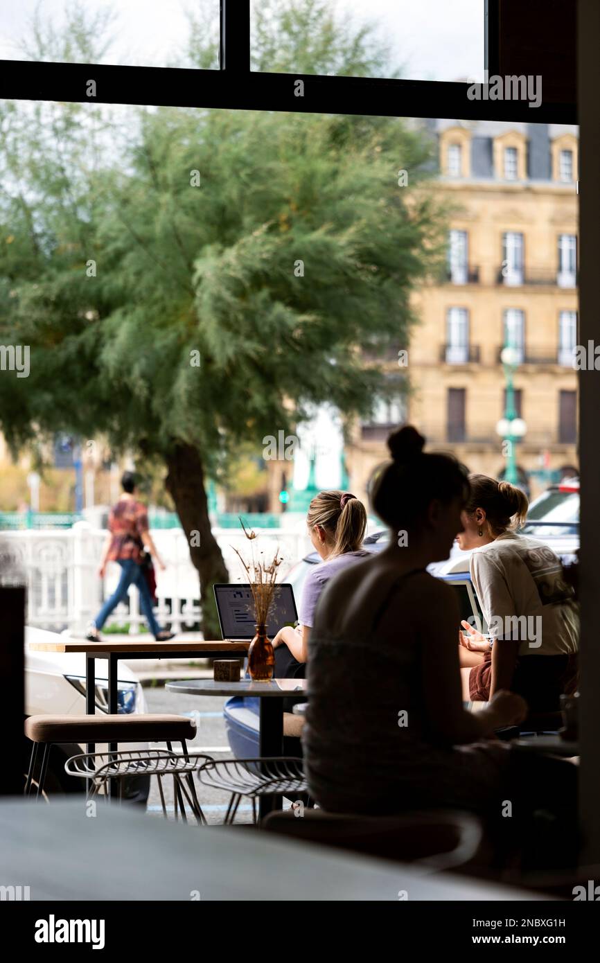 Two women sitting at a cafe working Stock Photo - Alamy
