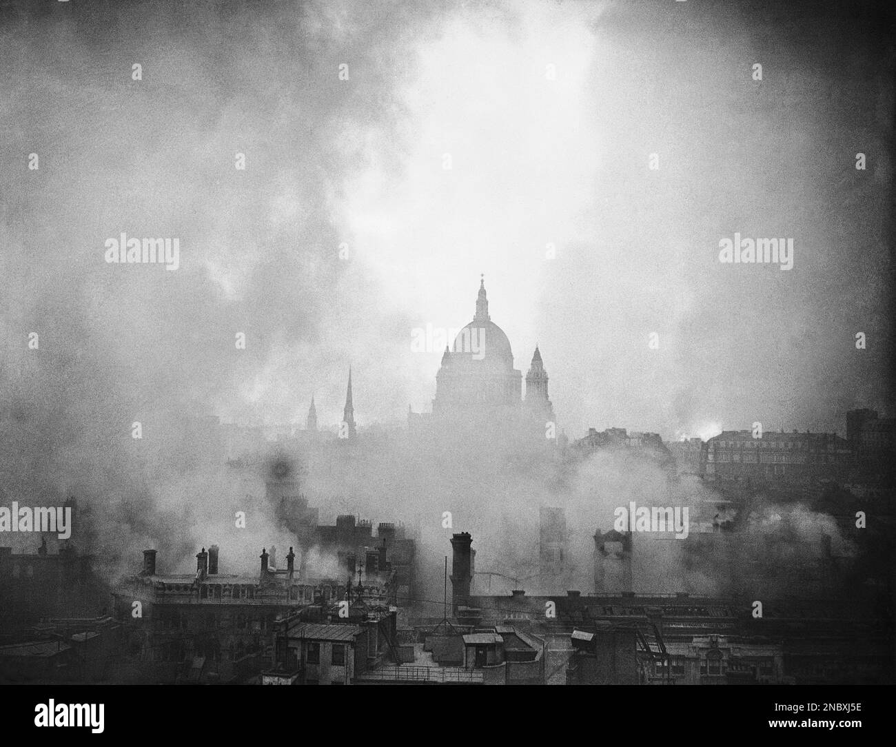 The dome of St. Paul's Cathedral silhouetted against the flame lit sky ...