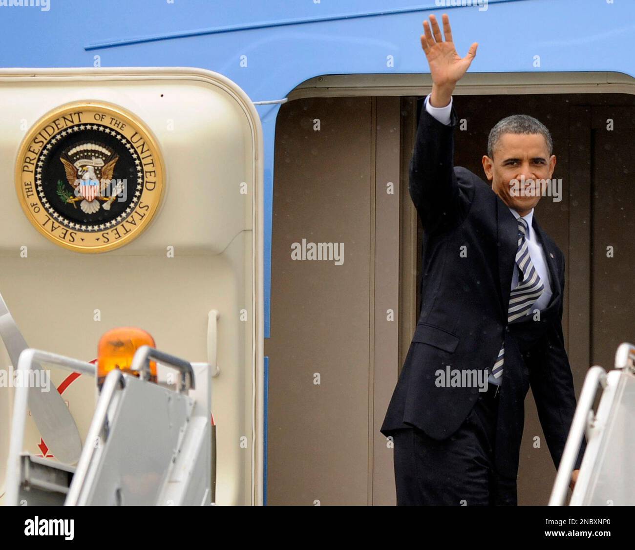 President Barack Obama waves while boarding Air Force One before ...