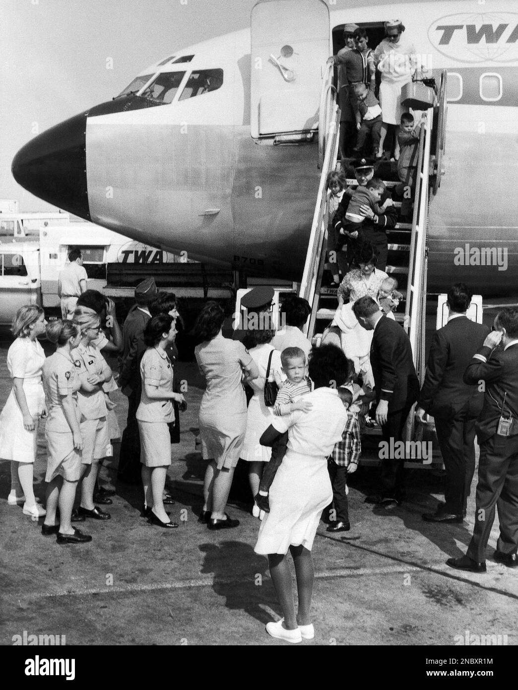 Women and children are aided by nurses waiting at Kennedy Airport as ...