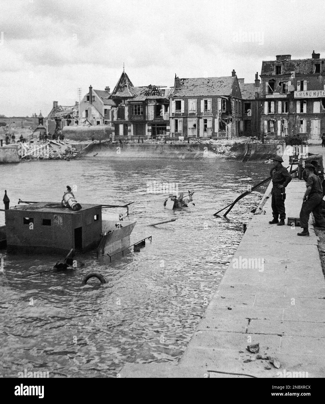 A sunken German flak ship, left, in the harbor and battered waterfront ...
