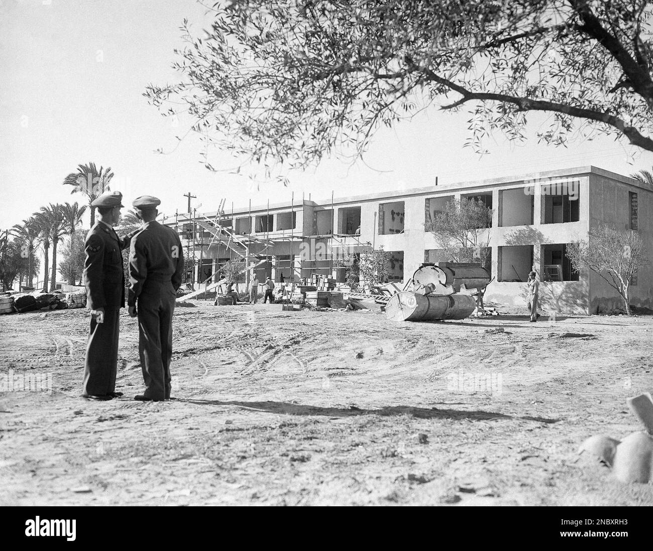 Two U.S. airmen look over the new barracks under construction at ...