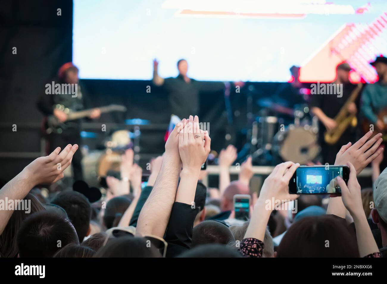 street open air. A big concert, a crowd of people welcomes their ...
