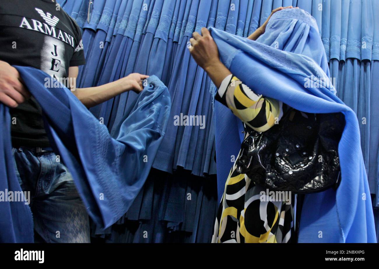 An Afghan woman removes her "Chadori", a traditional head to toe veiled ...