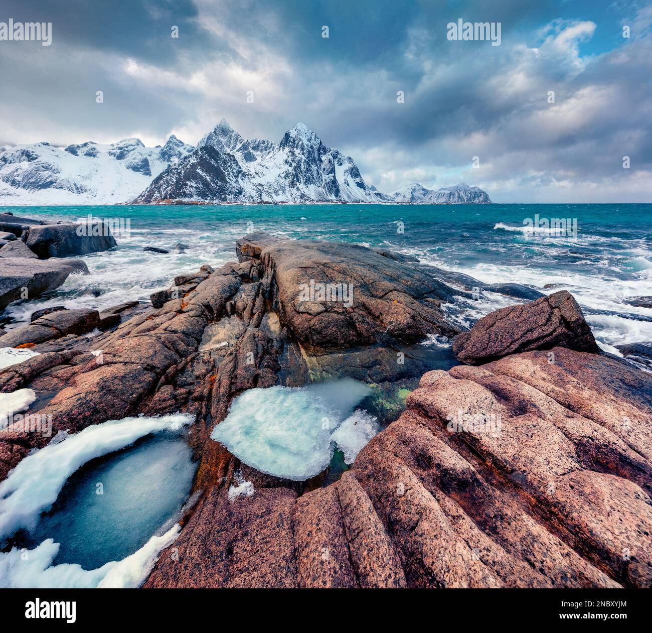 Gloomy spring view of Lofoten Islands. Melting snow on Flakstadpollen ...