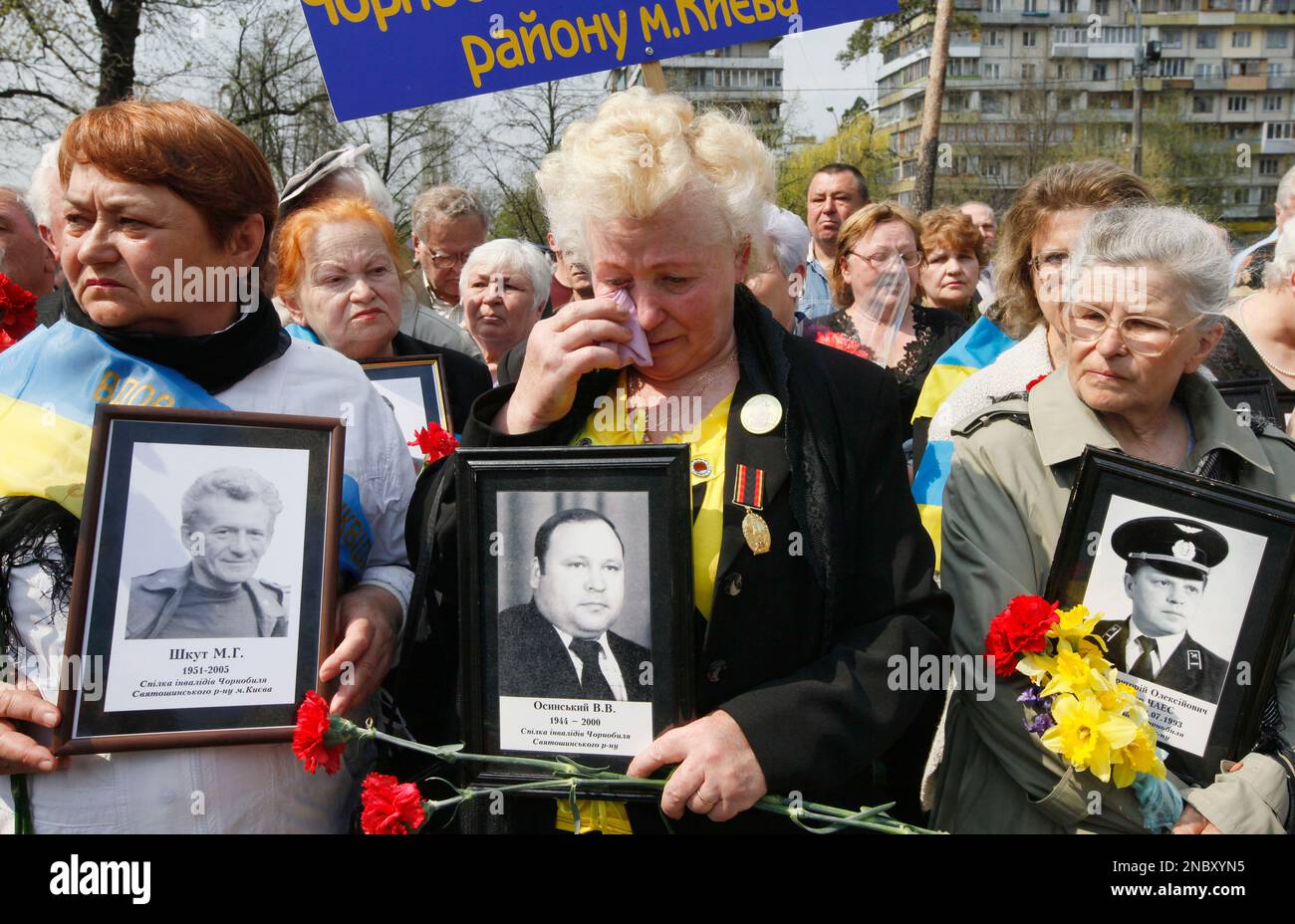 The widows of Chernobyl victims hold portraits of their husbands who ...