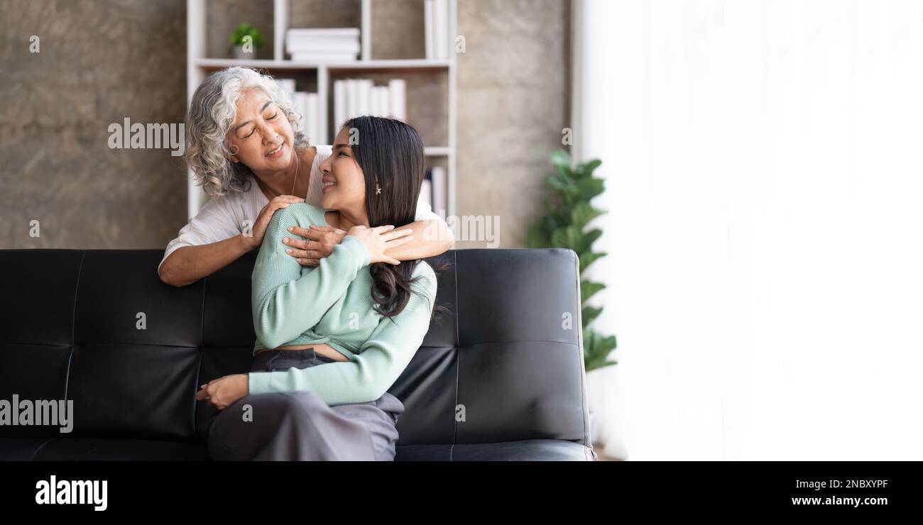 Mother and daughter hugging at home. Happy senior mom and adult daughter embracing with love ...