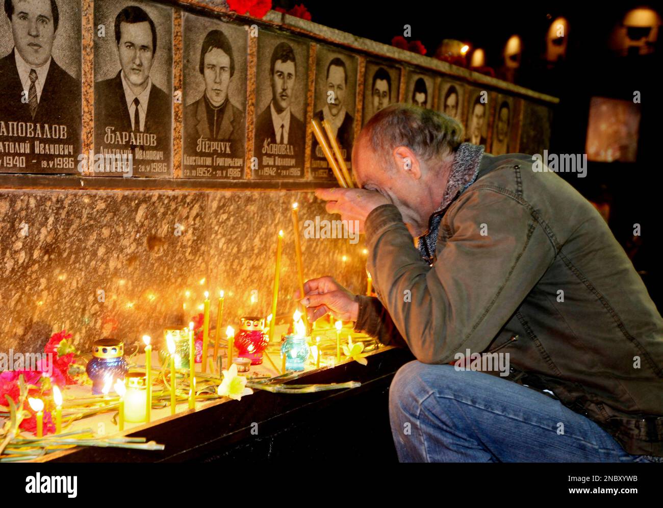A Ukrainian lights candles to commemorate those who died after the ...
