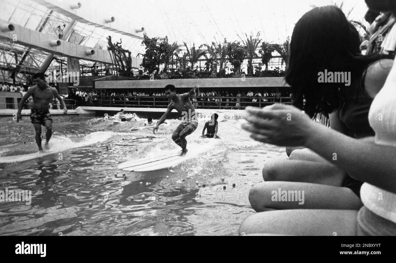 Japanese youths are seen enjoying indoor surfing in a big swimming pool ...